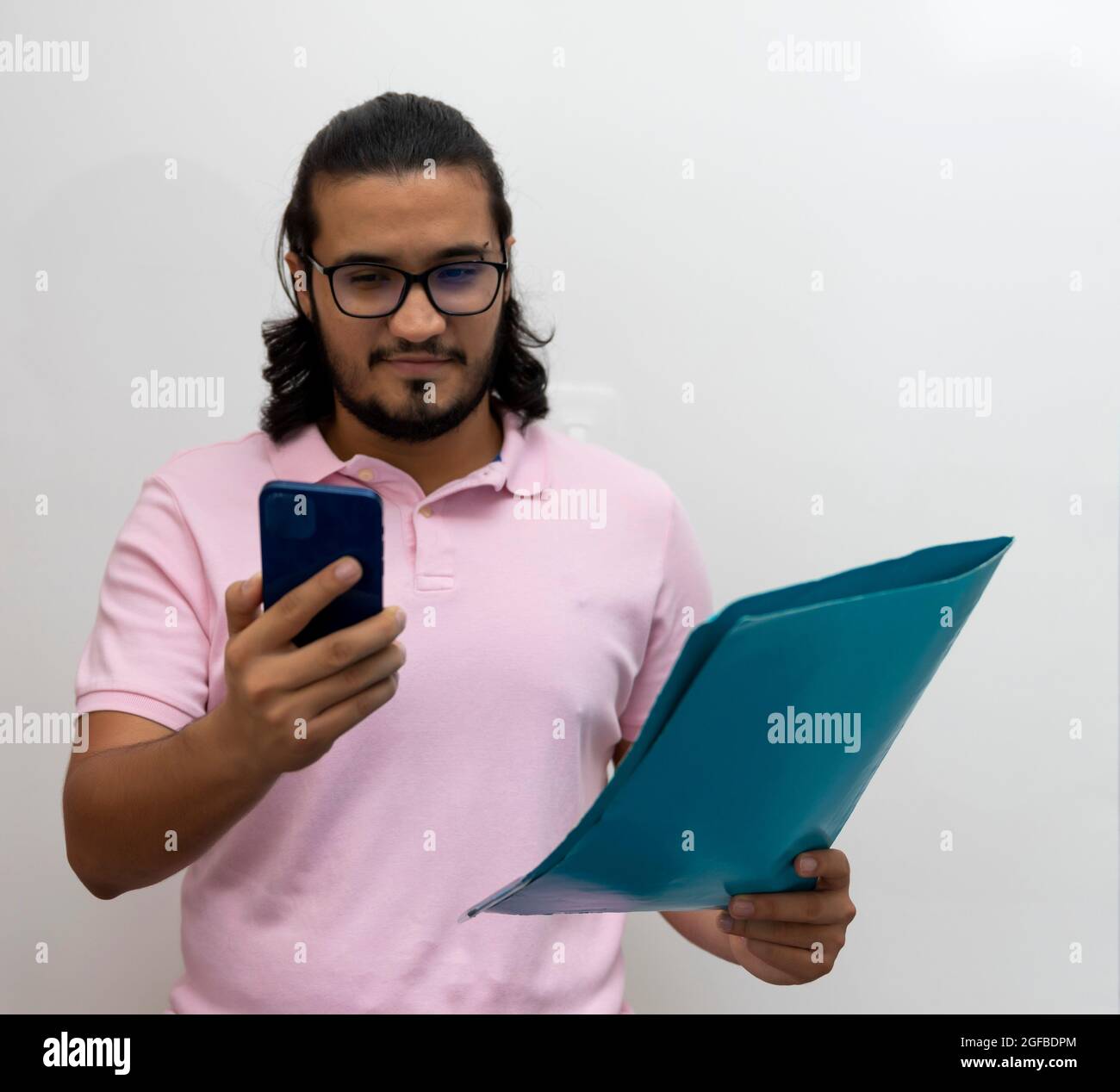 latino man with mobile phone and folder working from home Stock Photo ...