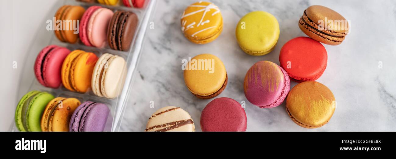 Many macarons at bakery in gift box. Panoramic banner of french sweet ...