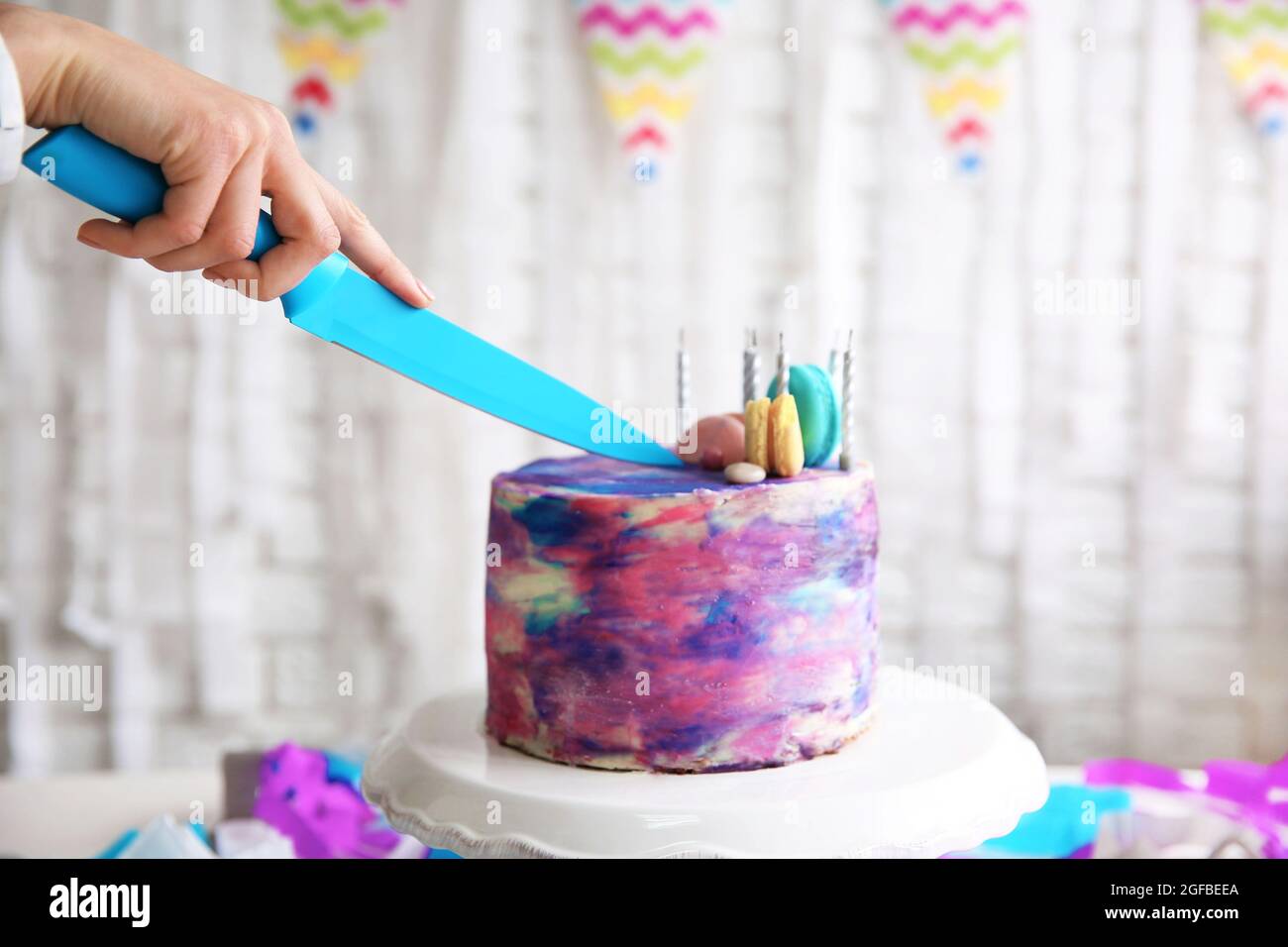 Female hand cutting festive cake on white stand Stock Photo - Alamy