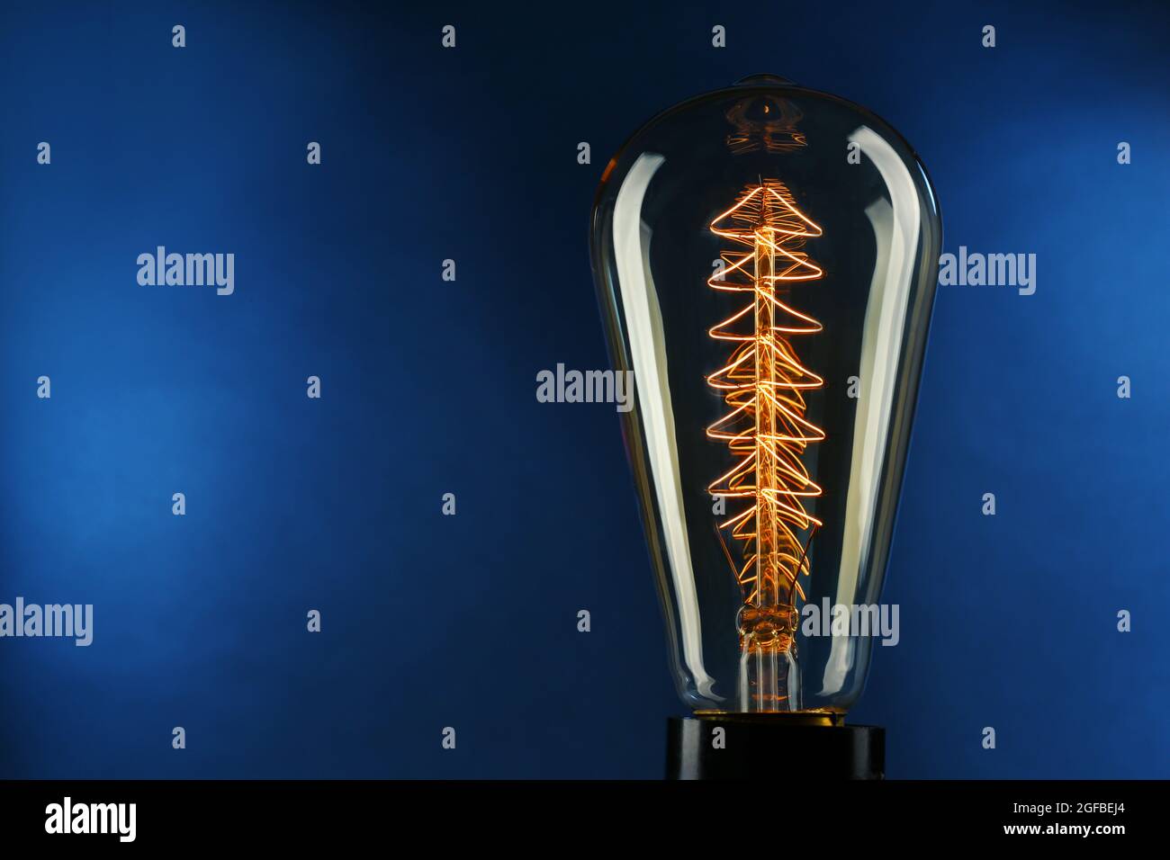 Illuminated light bulb on dark blue background Stock Photo - Alamy