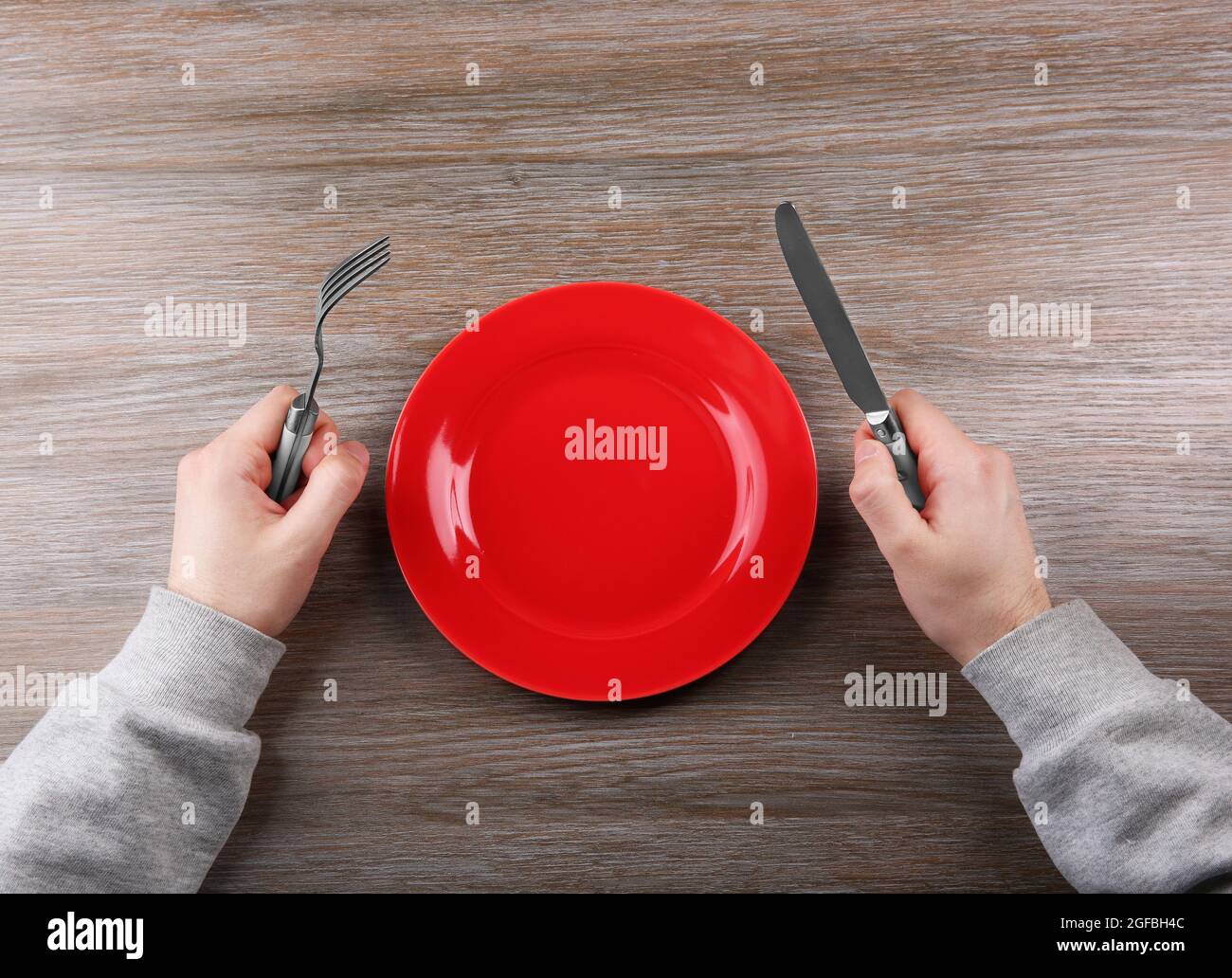 Man holding fork and knife with empty plate. Hunger concept Stock Photo ...