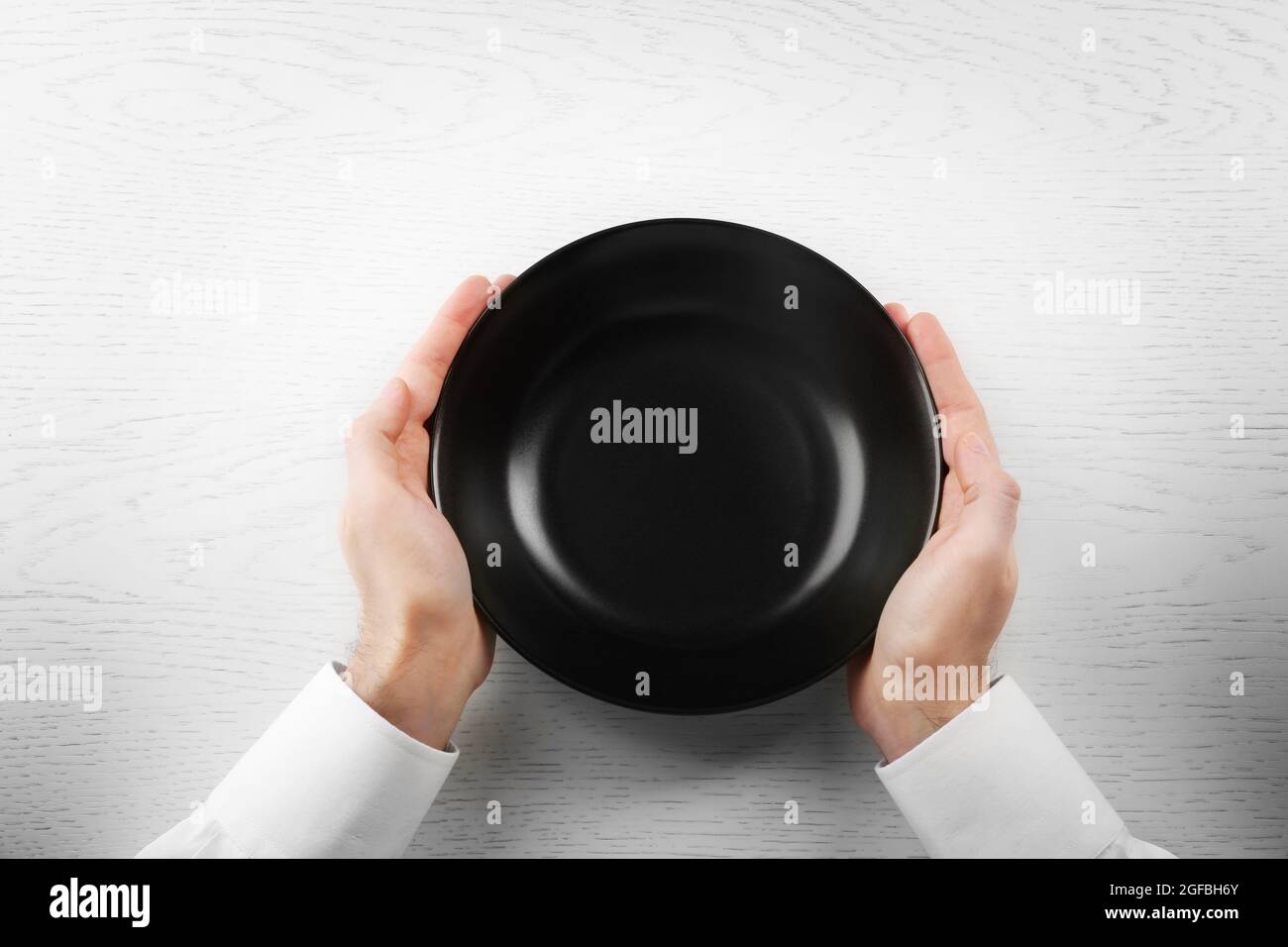 Man holding empty plate. Hunger concept Stock Photo - Alamy