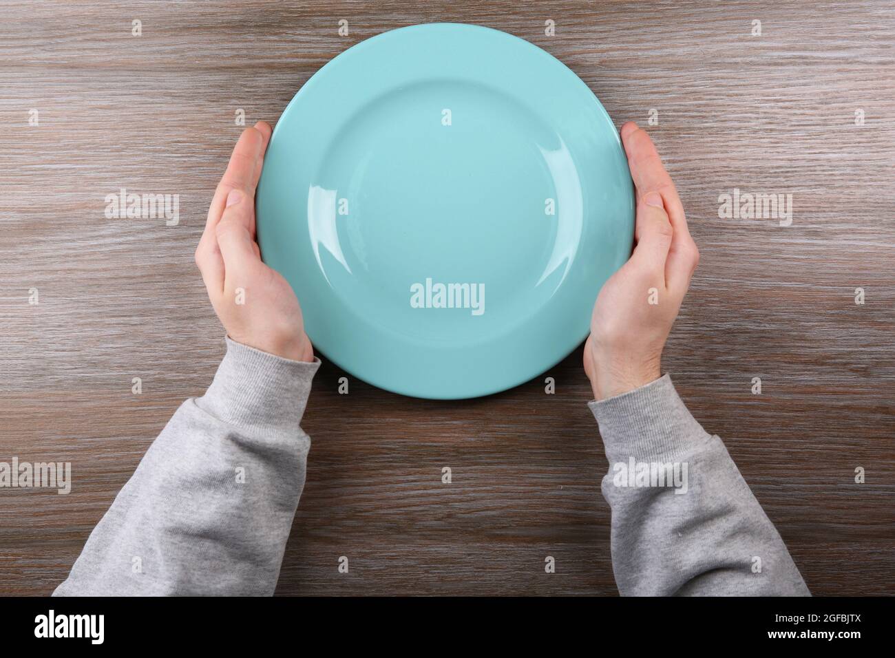 Man holding empty plate. Hunger concept Stock Photo - Alamy