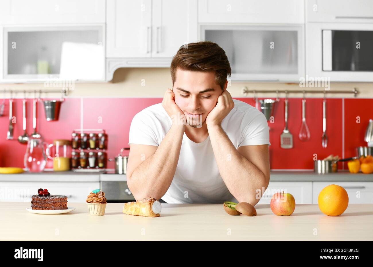 Man with healthy and unhealthy food in kitchen Stock Photo - Alamy