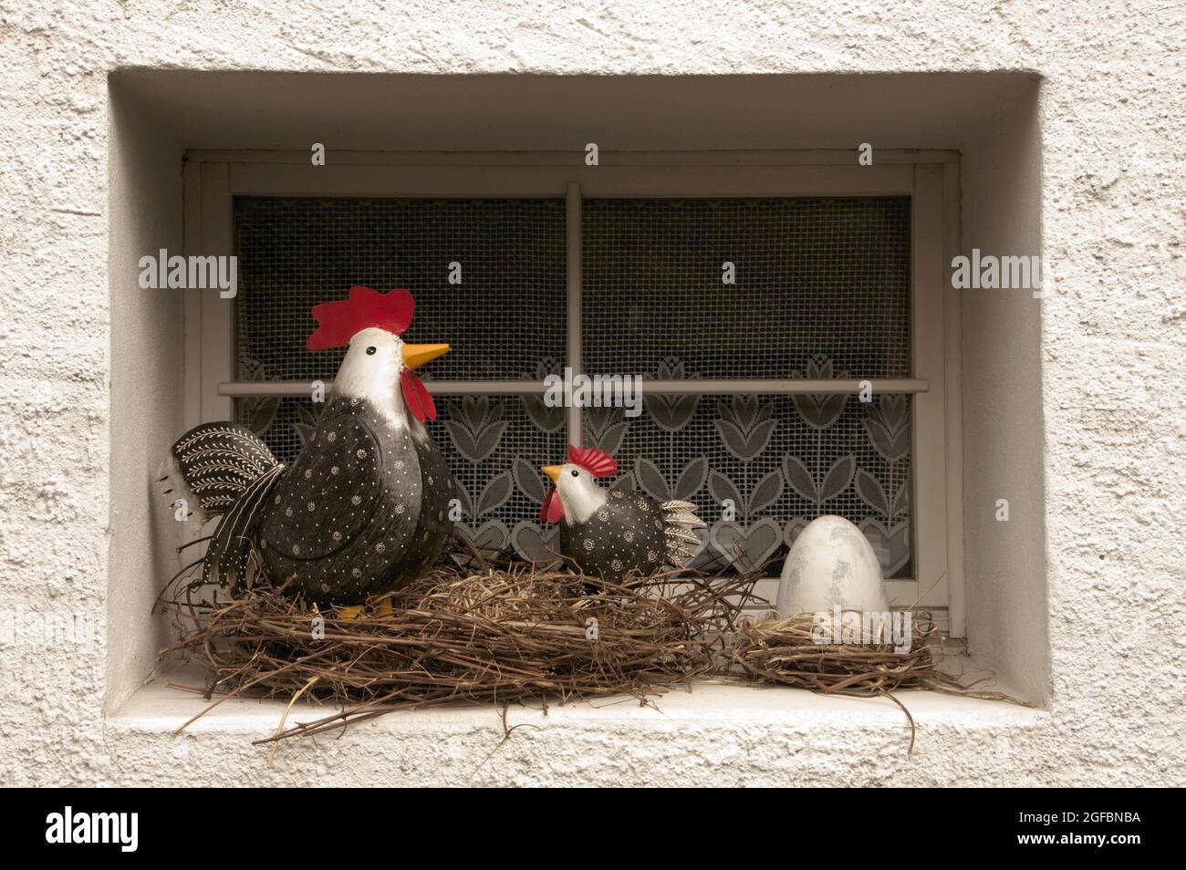 Metal chicken ornaments displayed on Swiss window-ledge Stock Photo - Alamy