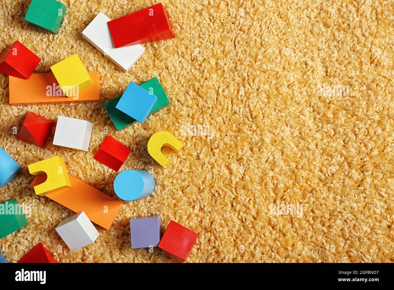 Colorful wooden kids toys on carpet Stock Photo - Alamy