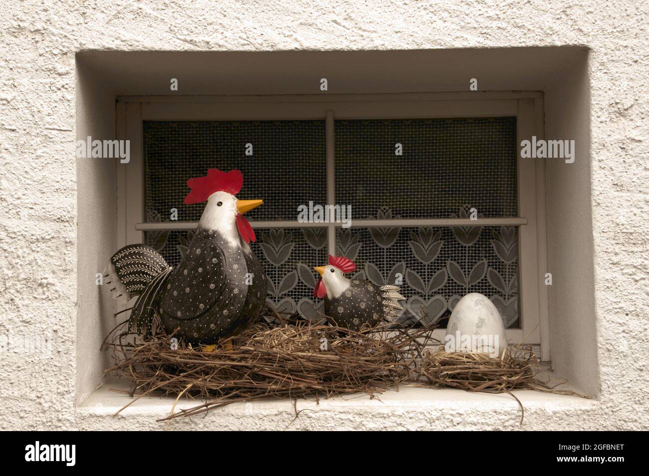 Metal chicken ornaments displayed on Swiss window-ledge Stock Photo - Alamy