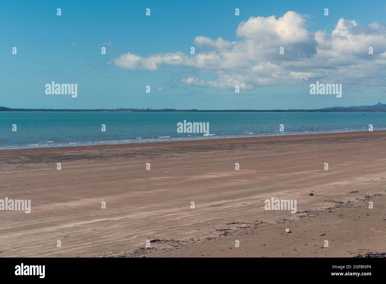 Cinematic color tones of a beach scene with a fisherman in the distance ...