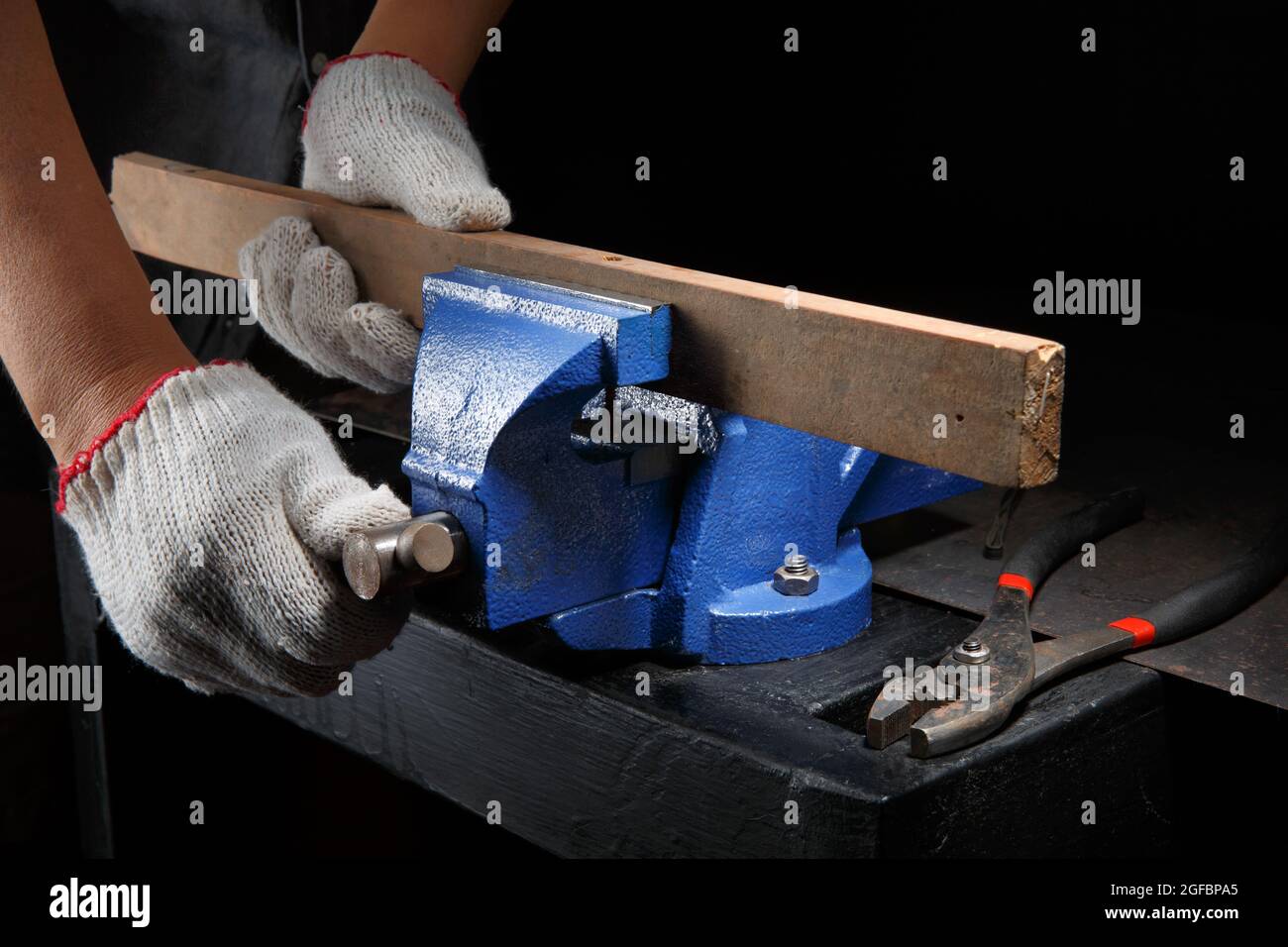 Closeup workers hands on a wooden plank locked in the iron vise Stock ...