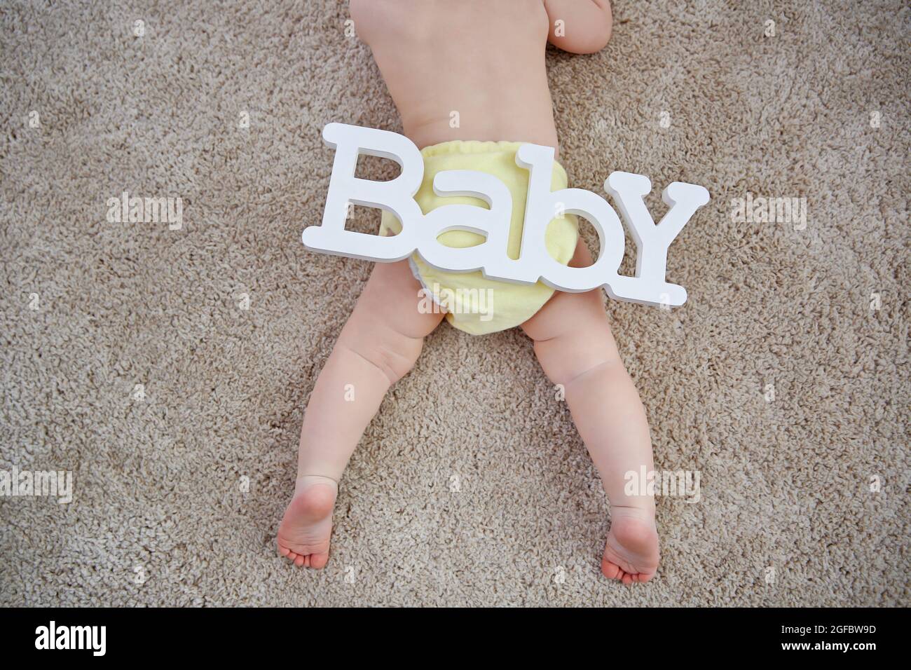 Baby and decorative word on the floor Stock Photo - Alamy