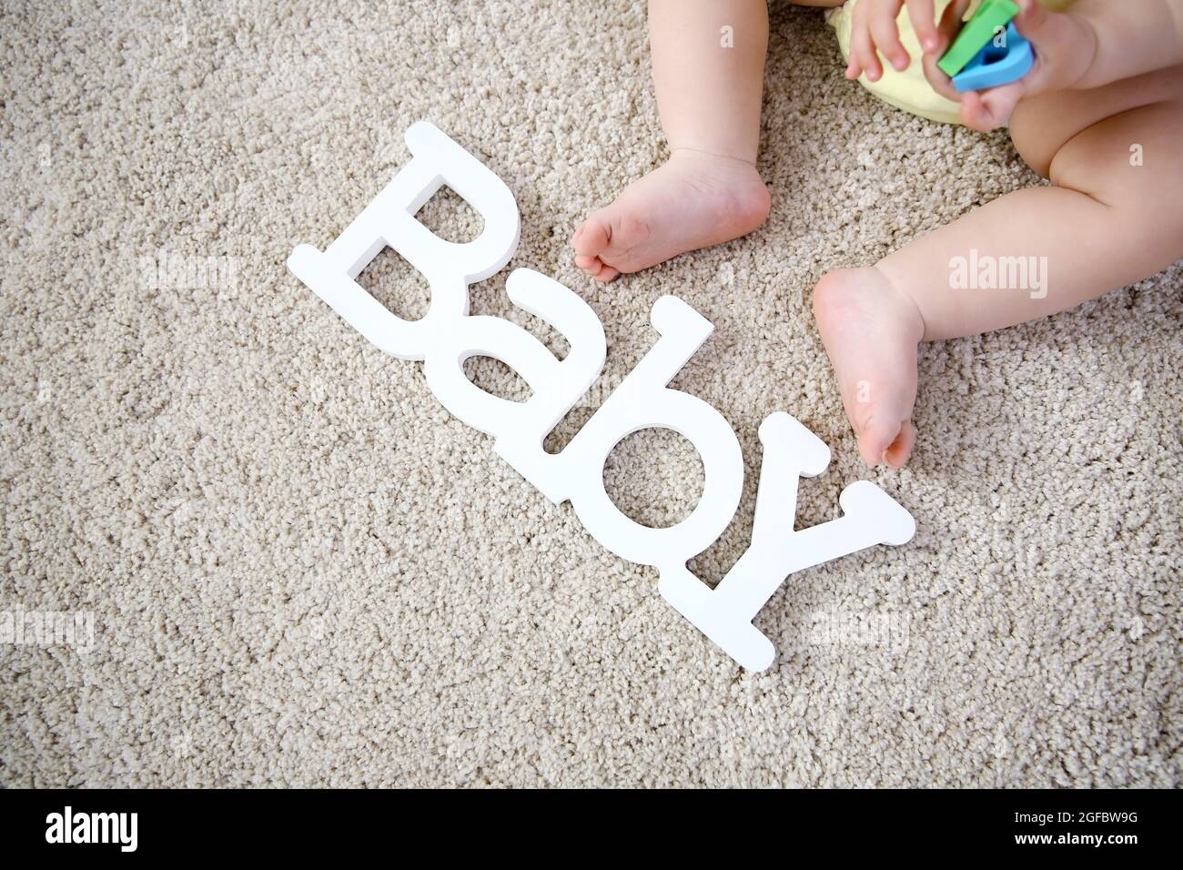 Baby legs and decorative word on the floor Stock Photo - Alamy