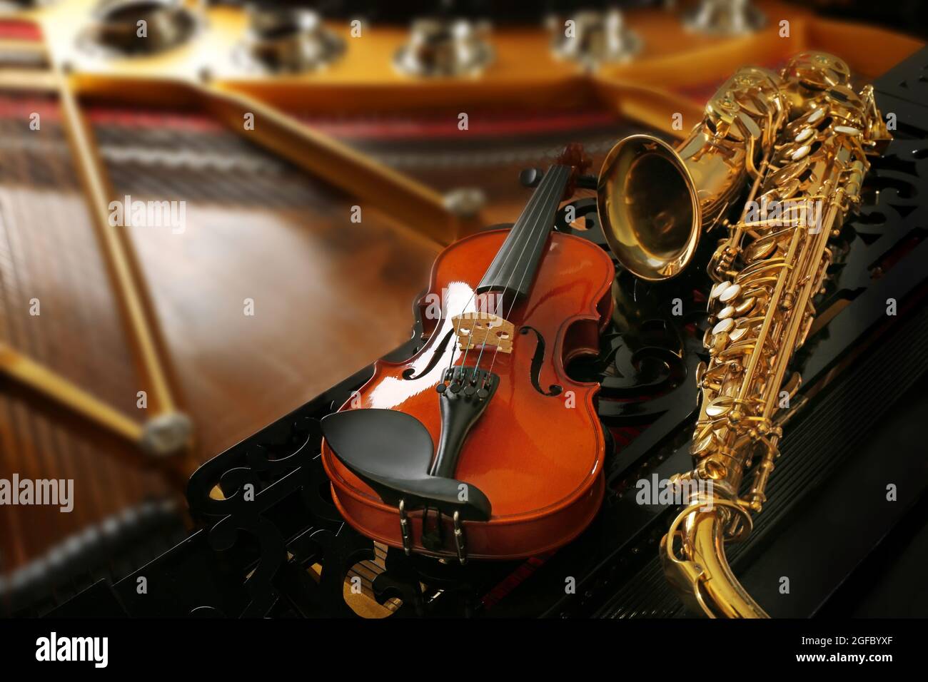 Violin and saxophone lying on piano, close up Stock Photo - Alamy