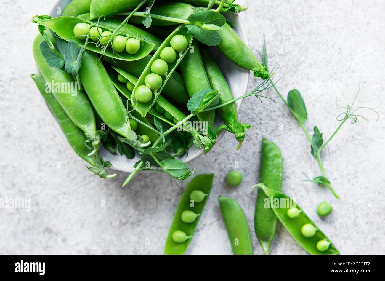 Fresh green peas pods and green peas with sprouts on concrete ...
