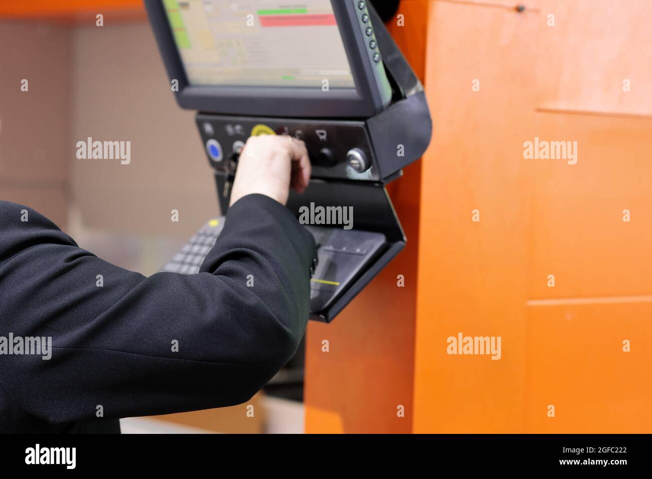 engineer working with a control panel of automated industrial equipment ...