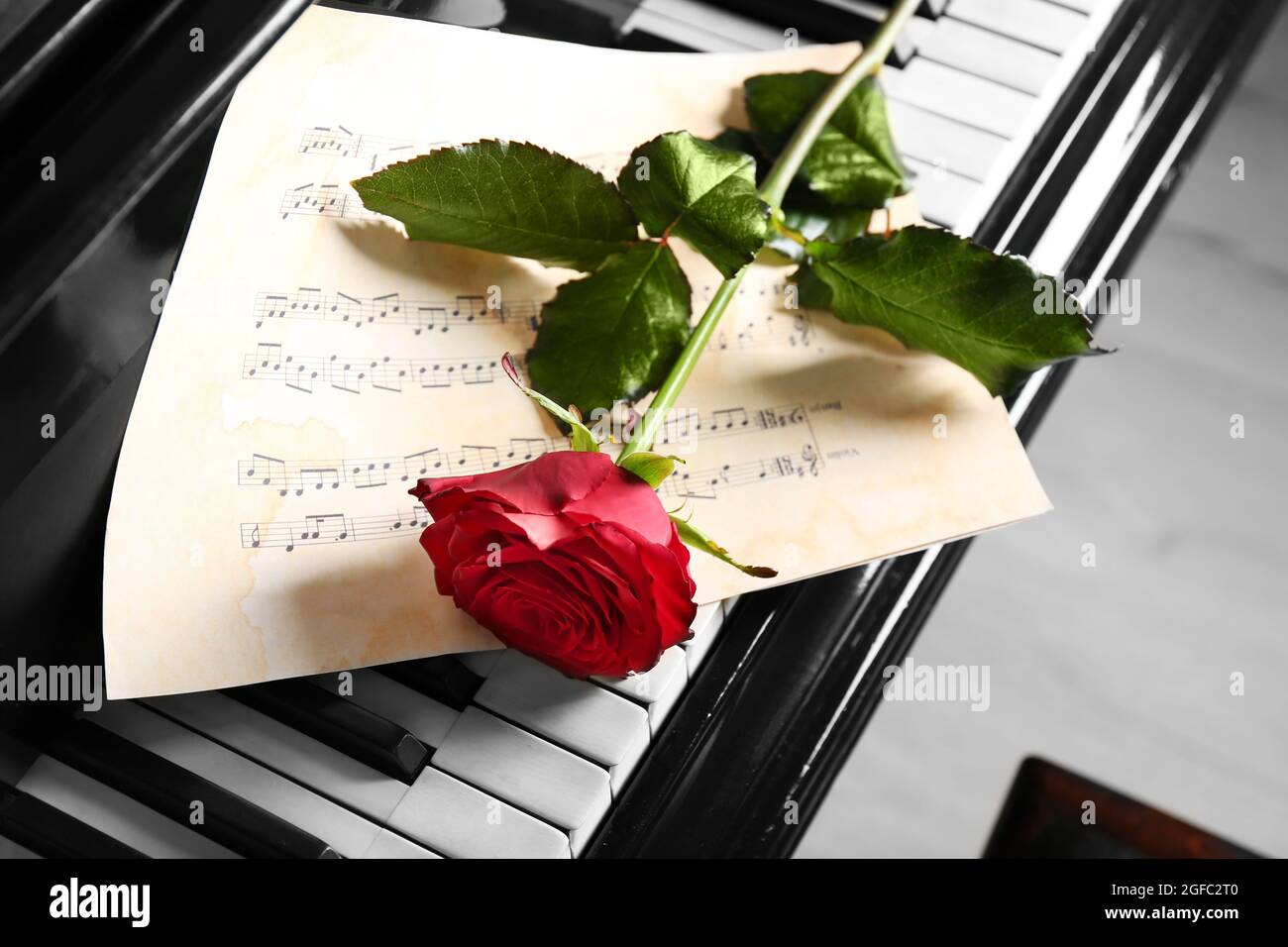Musical notes and red rose on piano keys, close up Stock Photo - Alamy