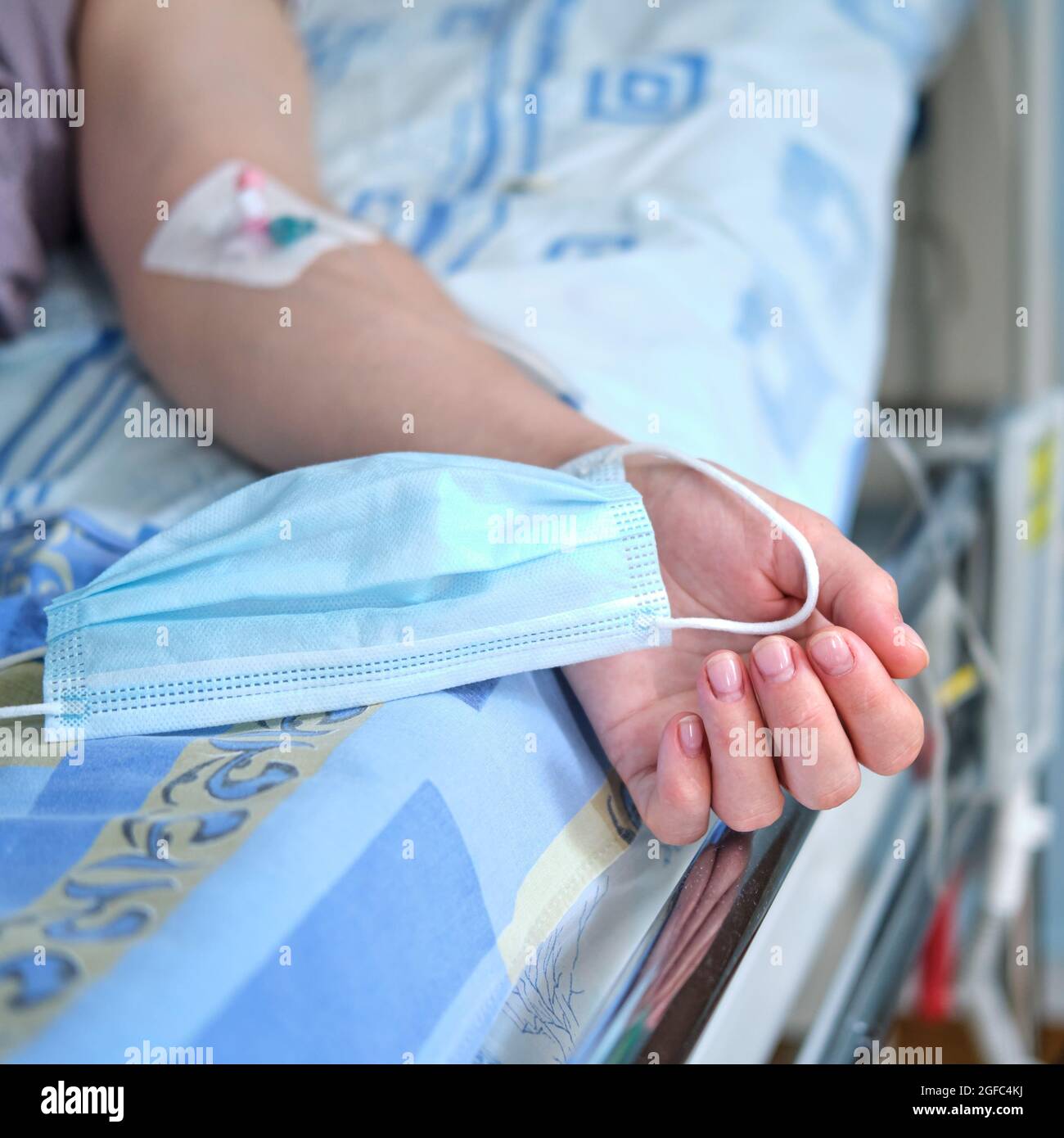 Pregnant woman with an IV on the bed. Hand with dropper needle and ...