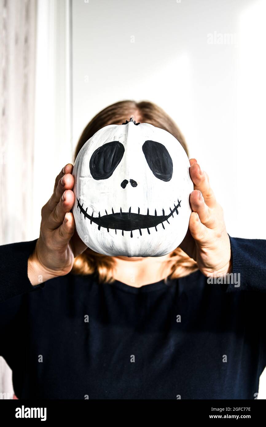 Woman holding Funny pumpkin face in front of her face. Halloween ...