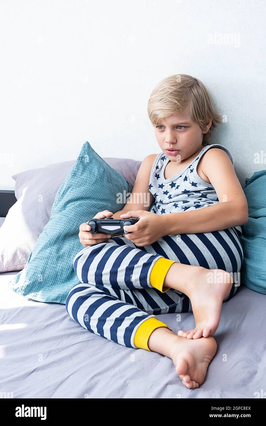 Boy holding joystick gaming controller in hands, playing video game at ...