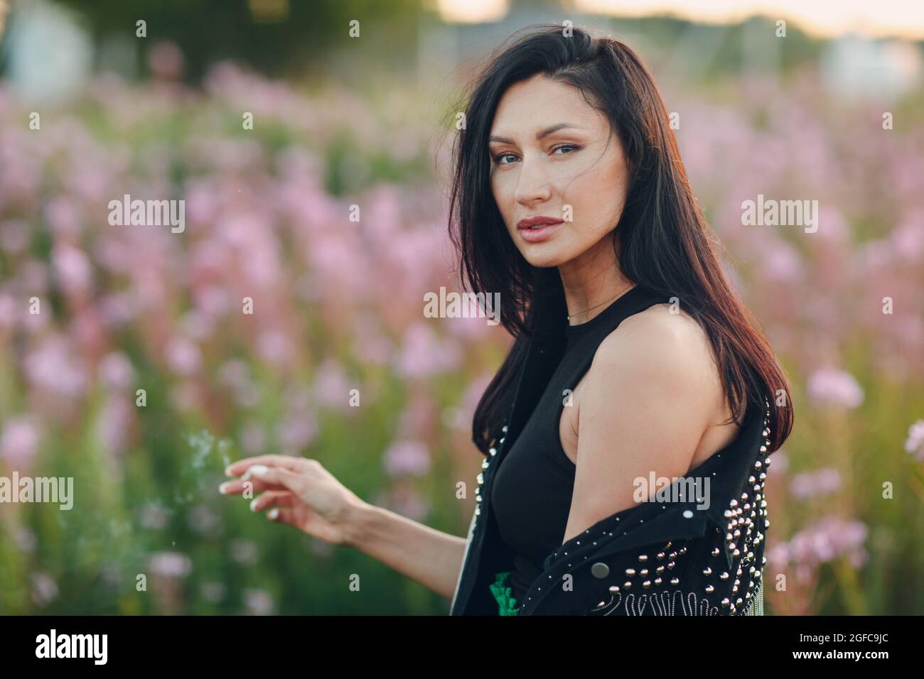 Young brunette woman on blooming Sally flower field. Lilac flowers and ...