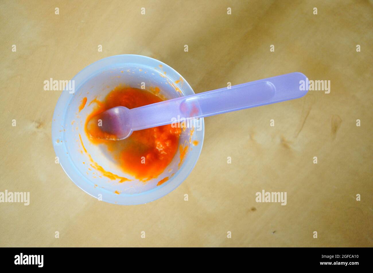 Top view of some puree in a plastic cup and spoon Stock Photo - Alamy