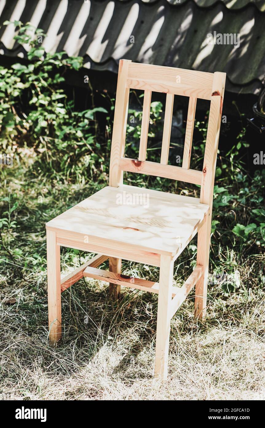 Vertical shot of a wooden chair on the grass Stock Photo - Alamy
