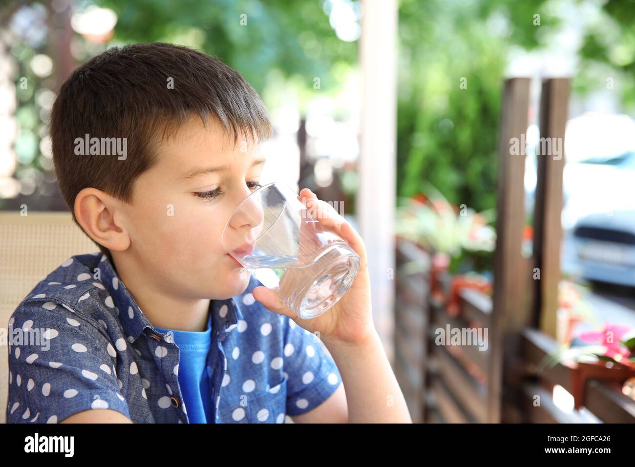 Cute boy drinking water in cafe Stock Photo - Alamy