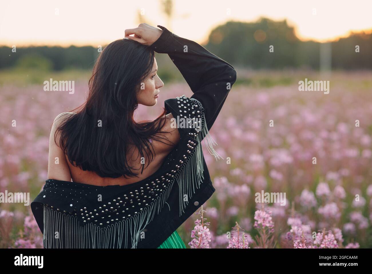 Young brunette woman on blooming Sally flower field. Lilac flowers and ...