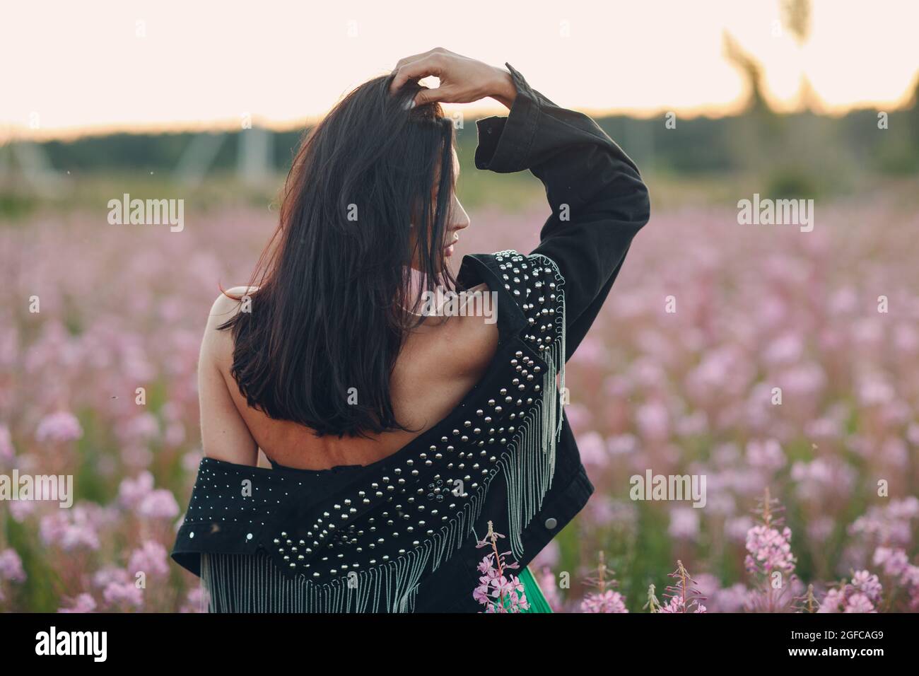 Young brunette woman on blooming Sally flower field. Lilac flowers and ...
