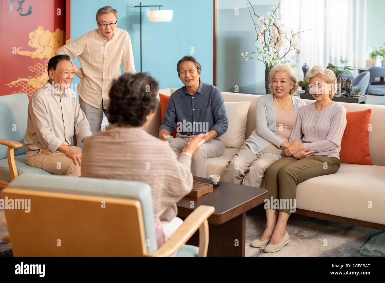 Happy friends talking in living room Stock Photo - Alamy