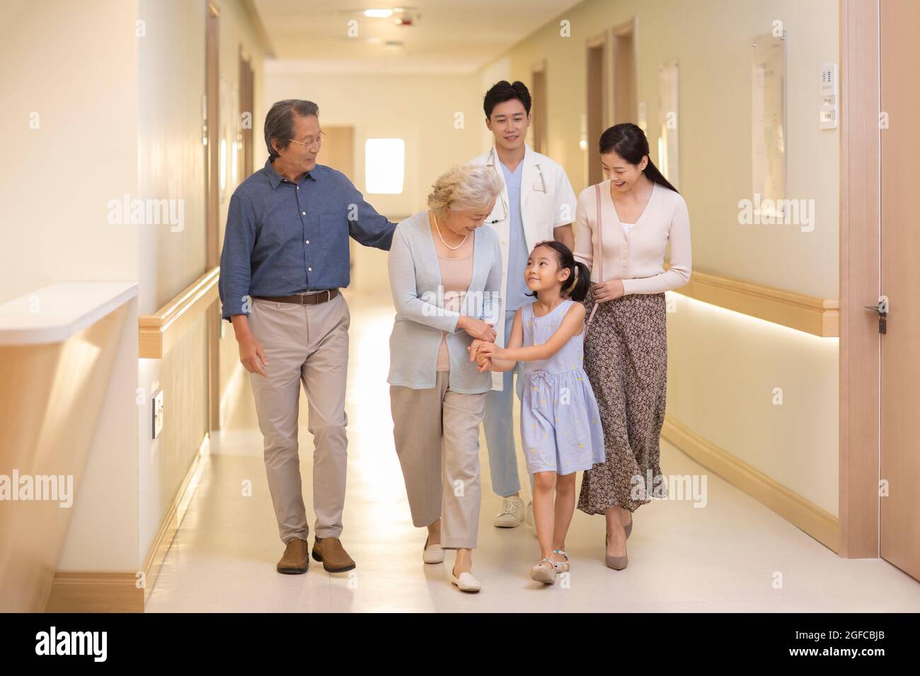 Family and doctor walking in hospital corridor Stock Photo - Alamy