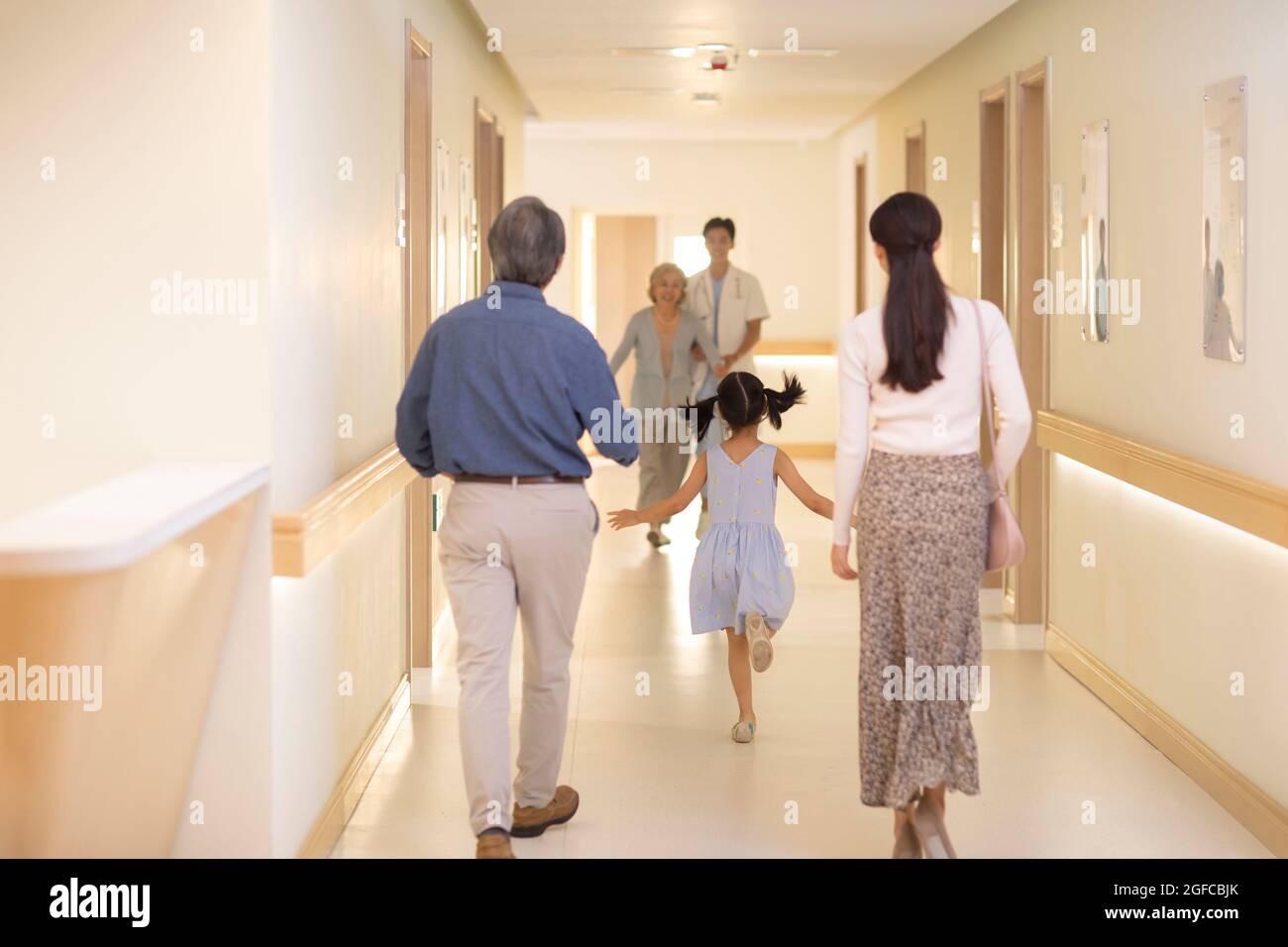 Little girl running to embrace grandmother in hospital corridor Stock ...