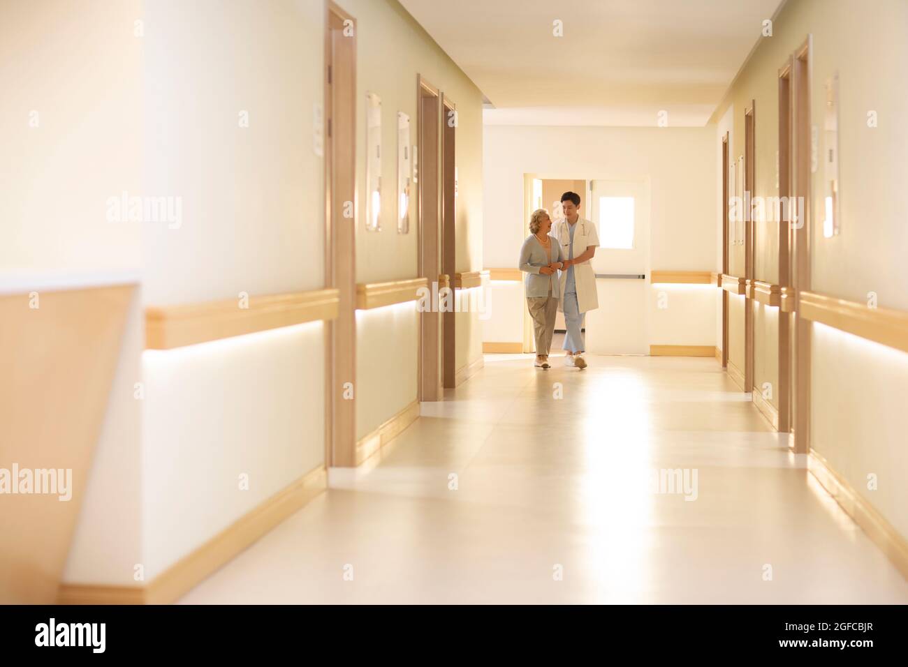 Doctor walking with patient in hospital corridor hi-res stock ...
