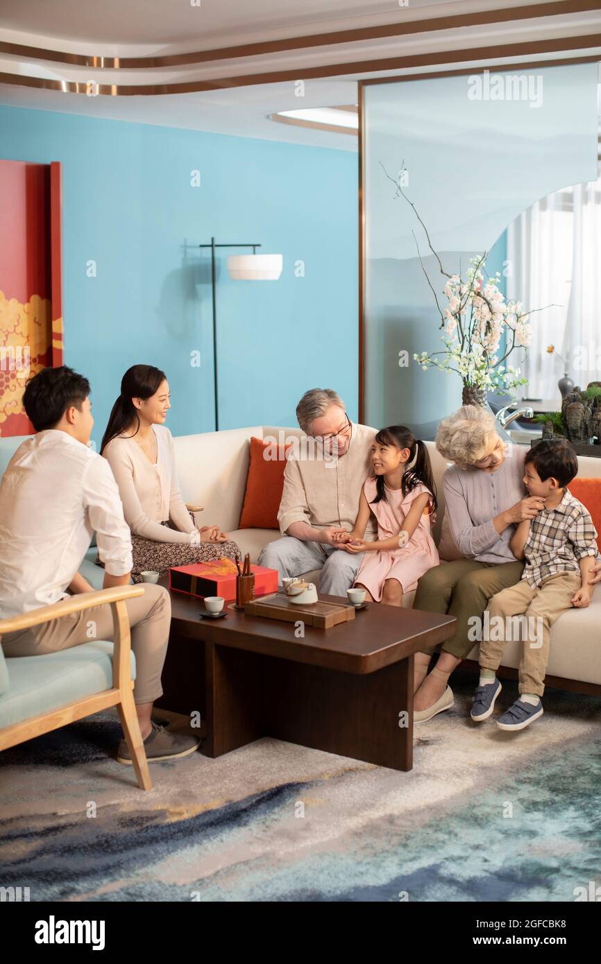 Happy family talking in living room Stock Photo - Alamy