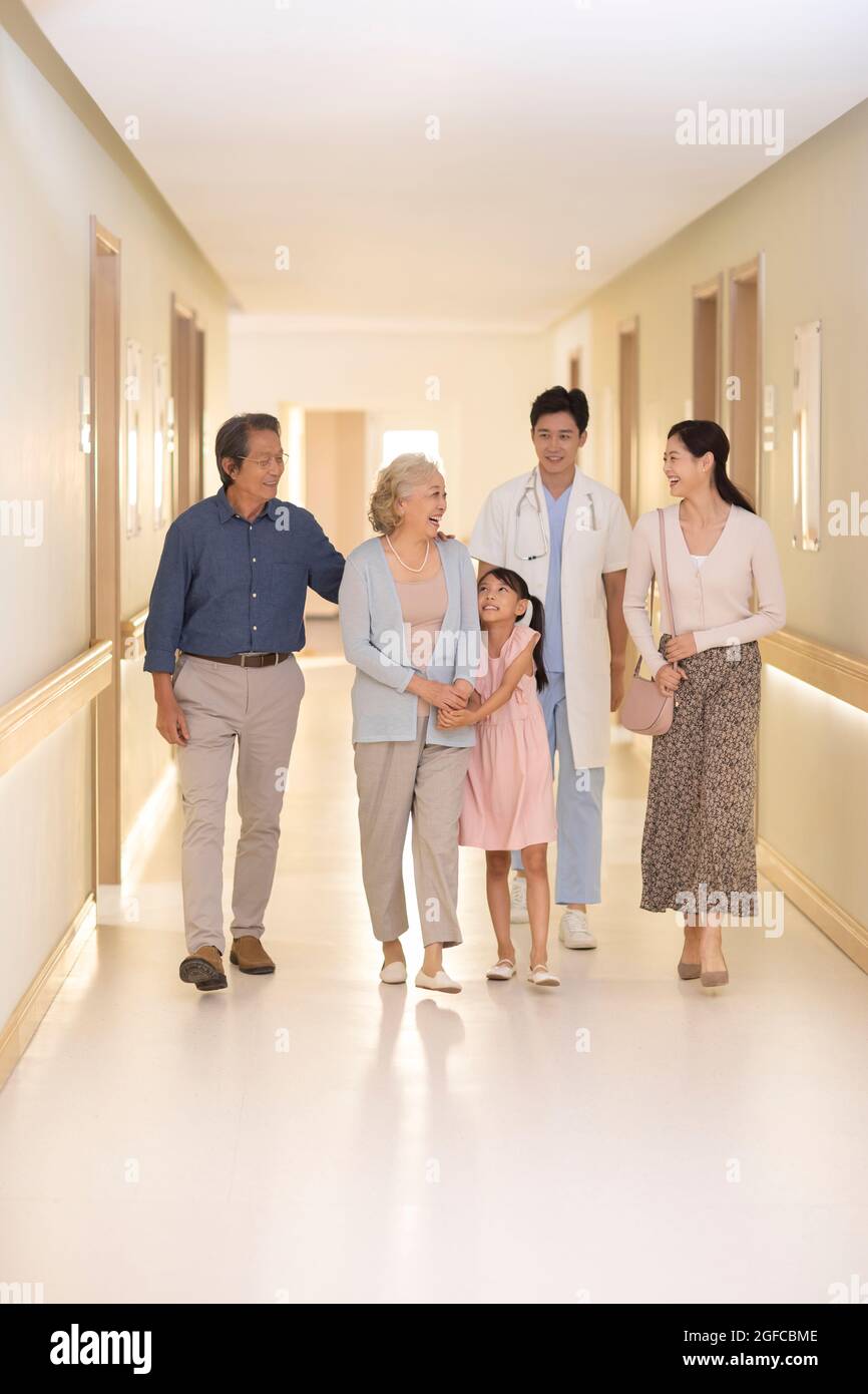 Family and doctor walking in hospital corridor Stock Photo - Alamy