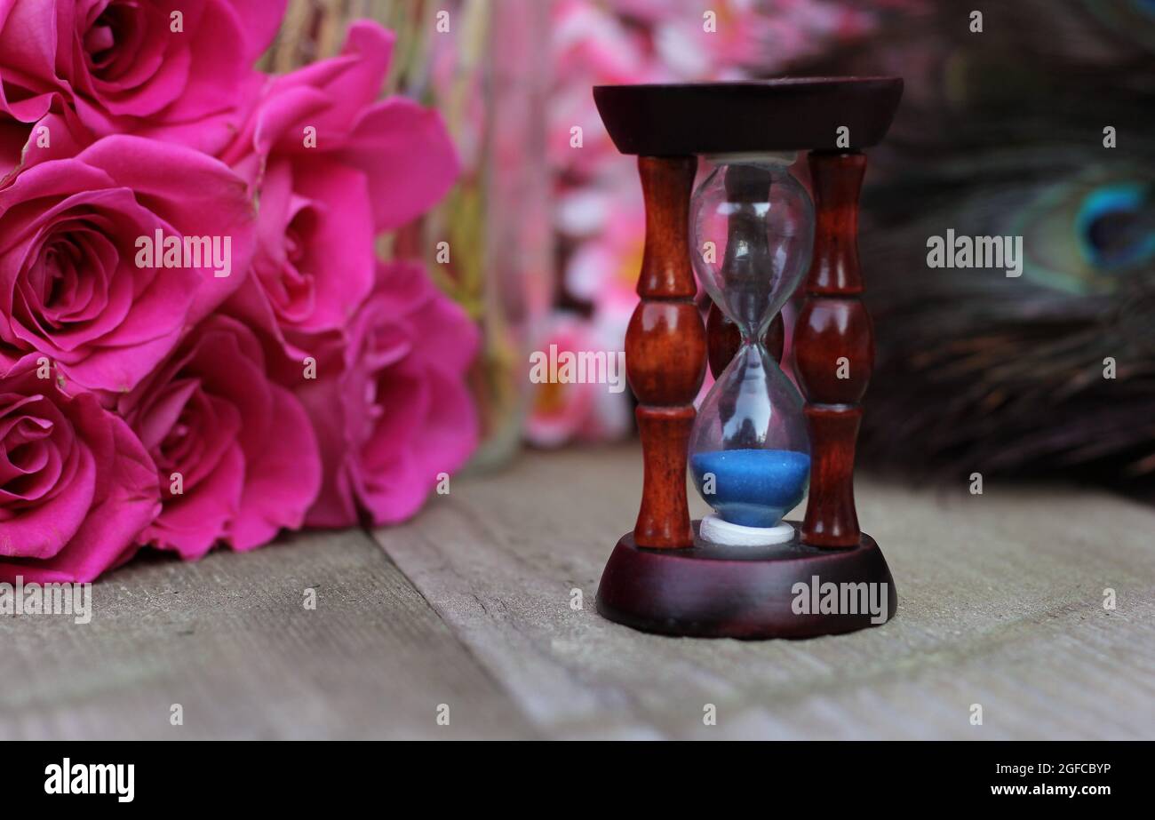 Vintage Hourglass With Pink Roses and Peacock Feathers Stock Photo - Alamy