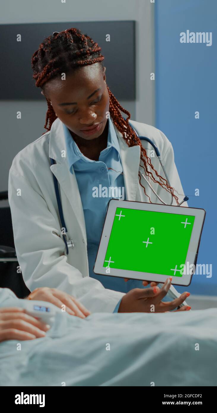 Specialist woman showing green screen on tablet to patient feeling sick ...