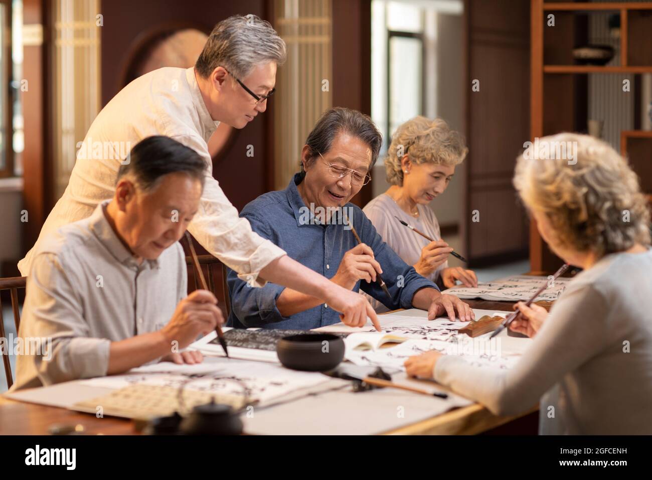 Happy friends practicing calligraphy together Stock Photo - Alamy