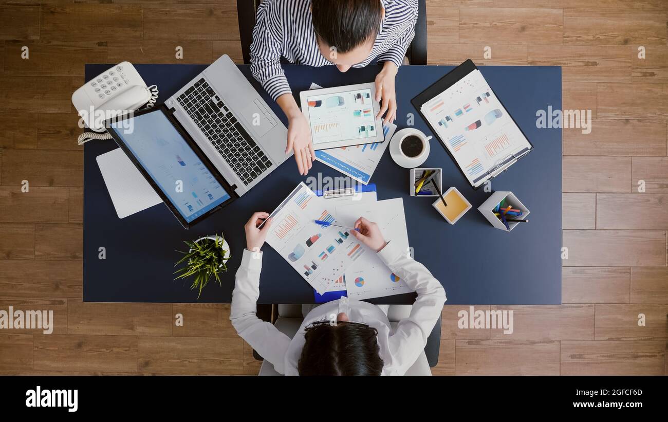 Top view of business women comparing financial graphs with management ...