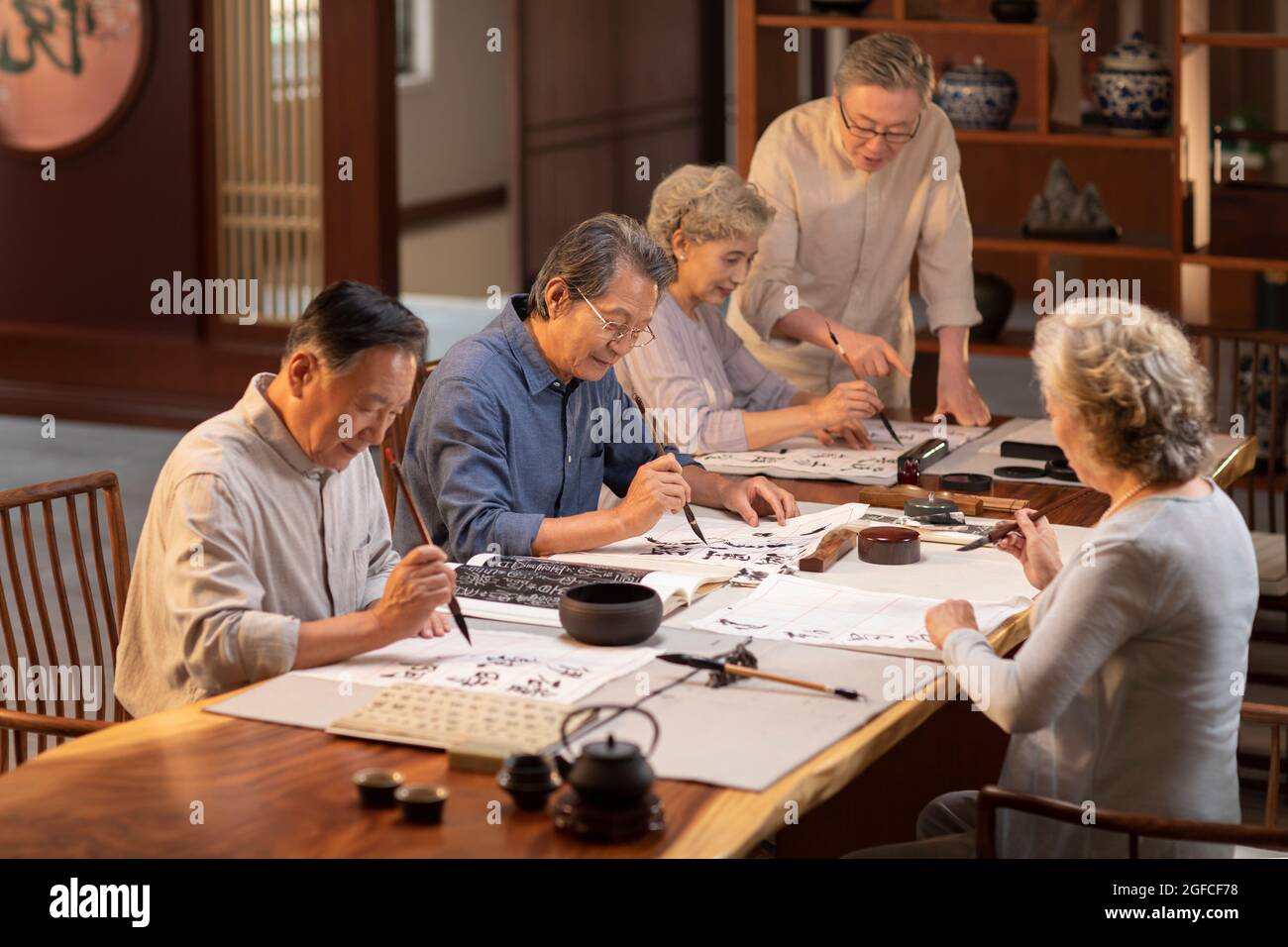 Happy friends practicing calligraphy together Stock Photo - Alamy