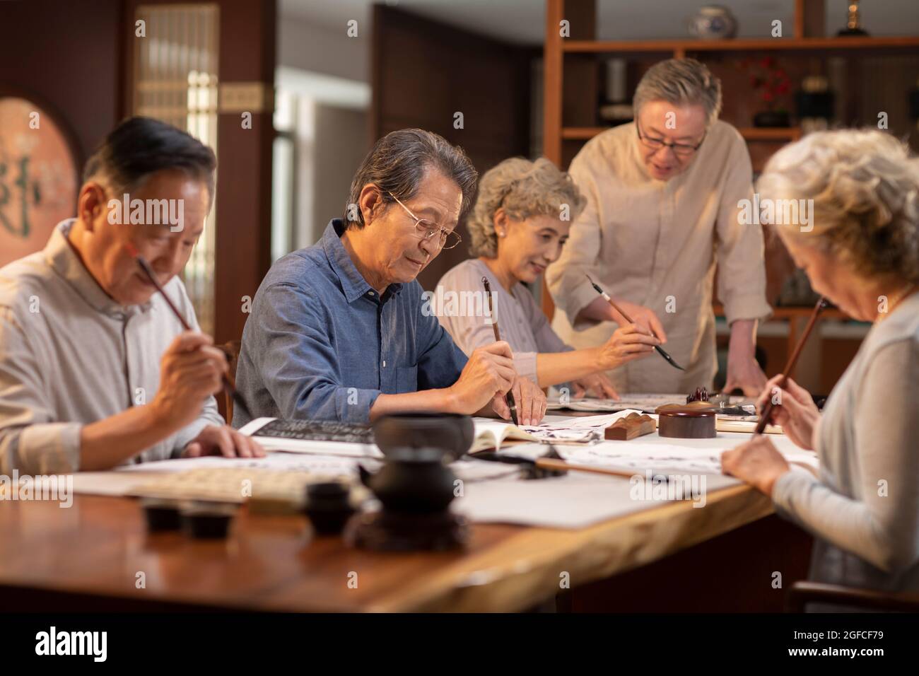 Happy friends practicing calligraphy together Stock Photo - Alamy