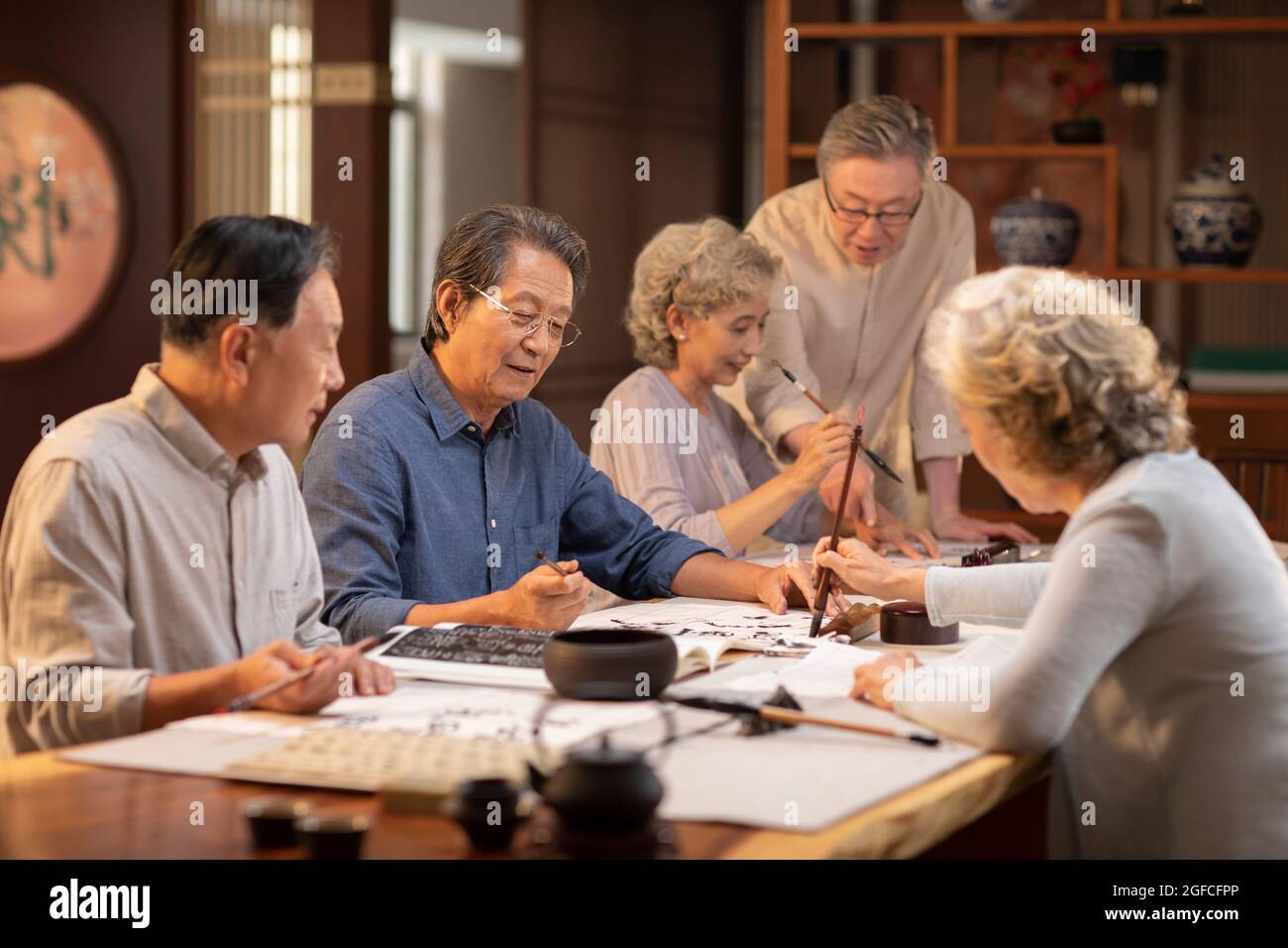Happy friends practicing calligraphy together Stock Photo - Alamy