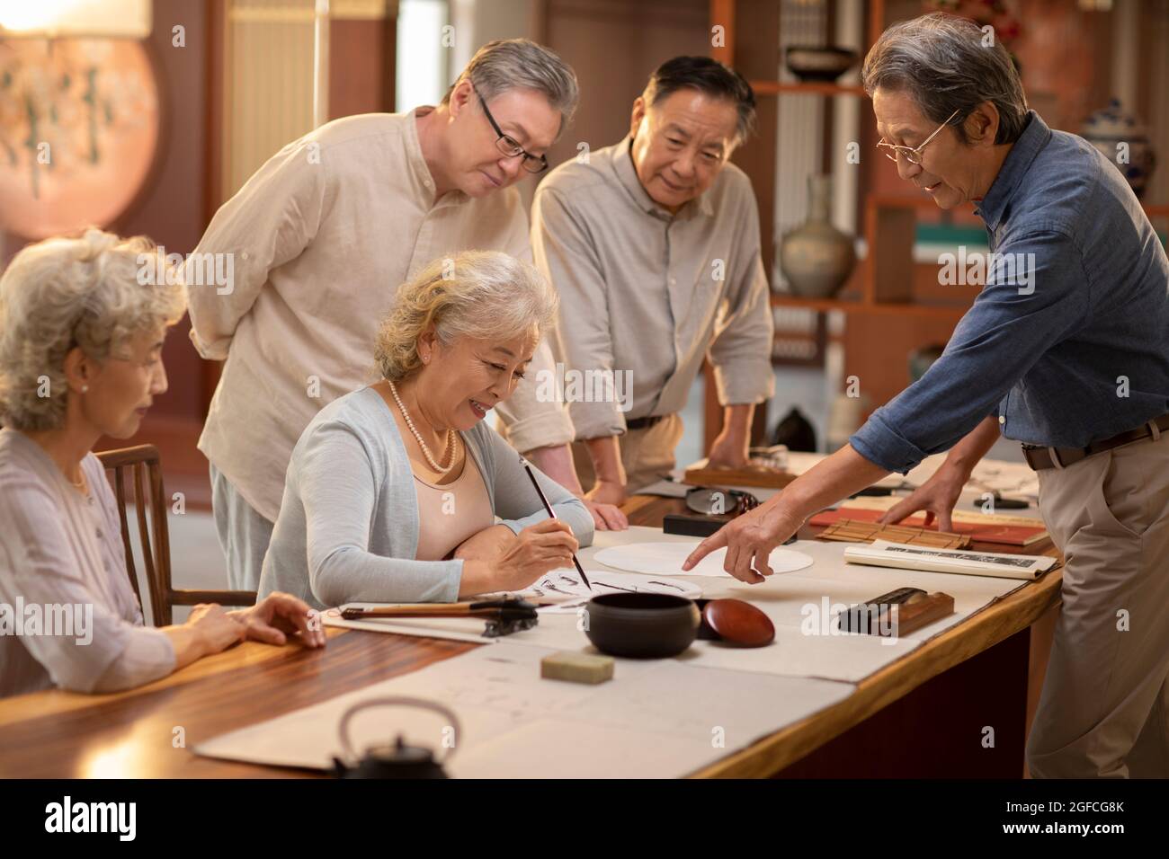 Happy friends drawing Chinese painting together Stock Photo - Alamy