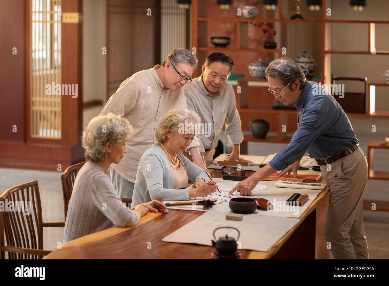 Happy friends drawing Chinese painting together Stock Photo - Alamy