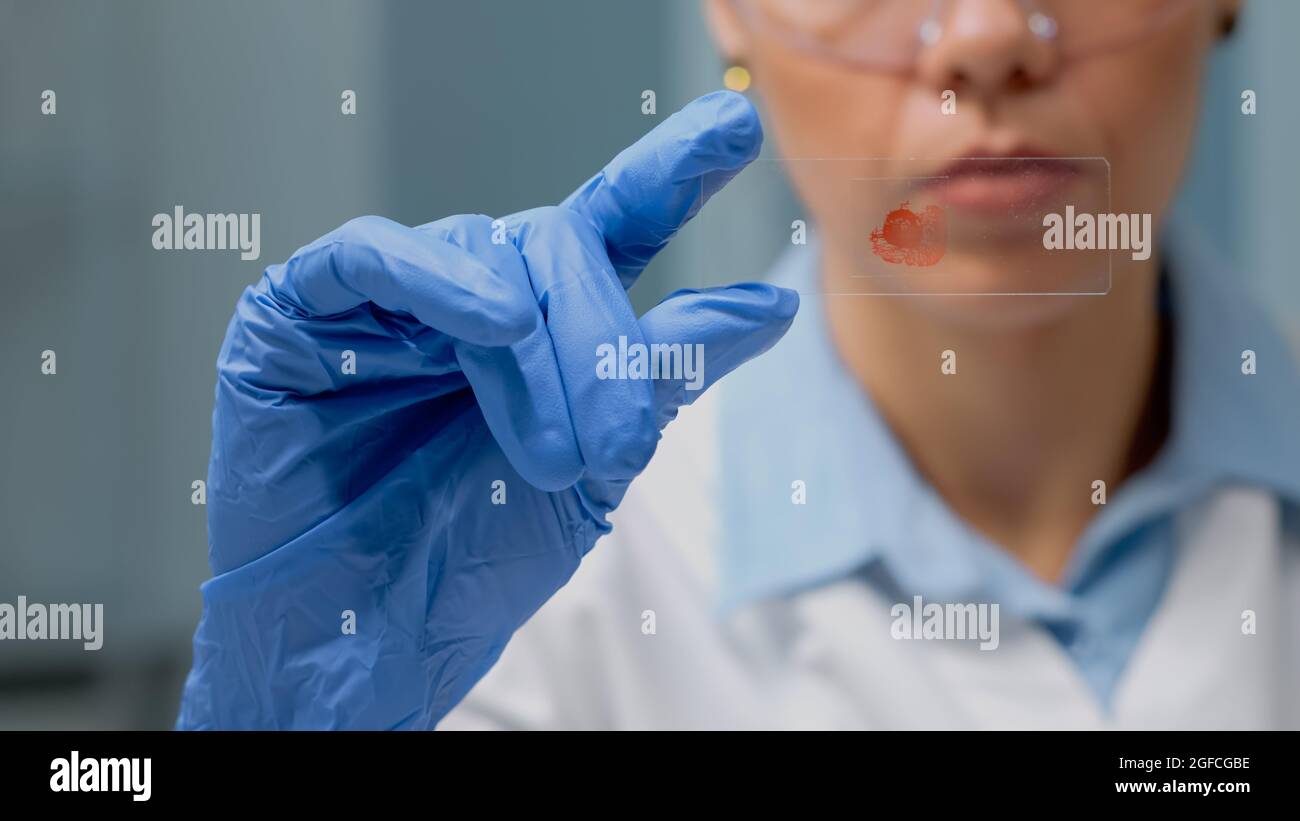 Close up of hand holding glass tray with blood for test experiment in ...