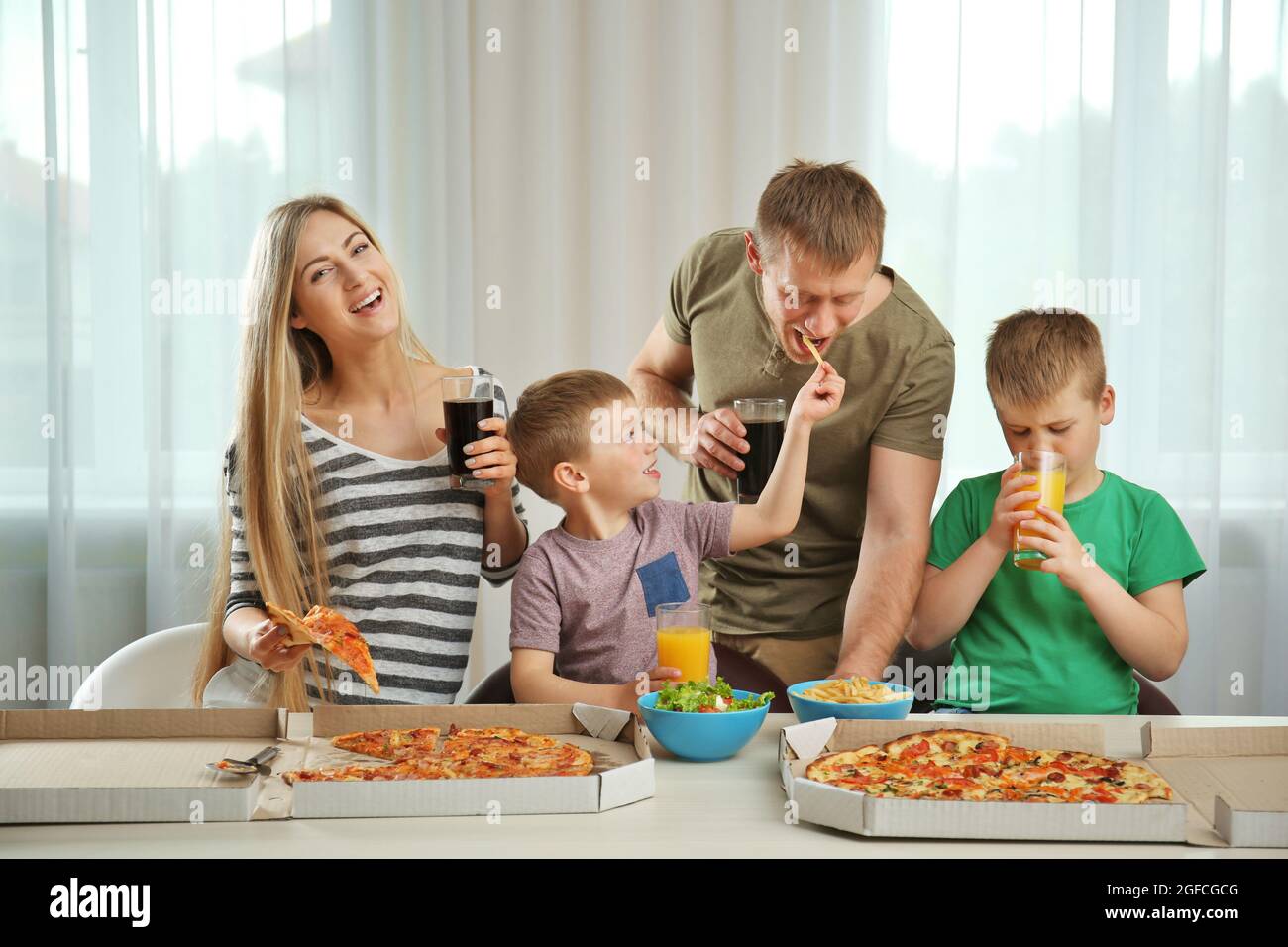 Happy lovely family eating pizza Stock Photo - Alamy