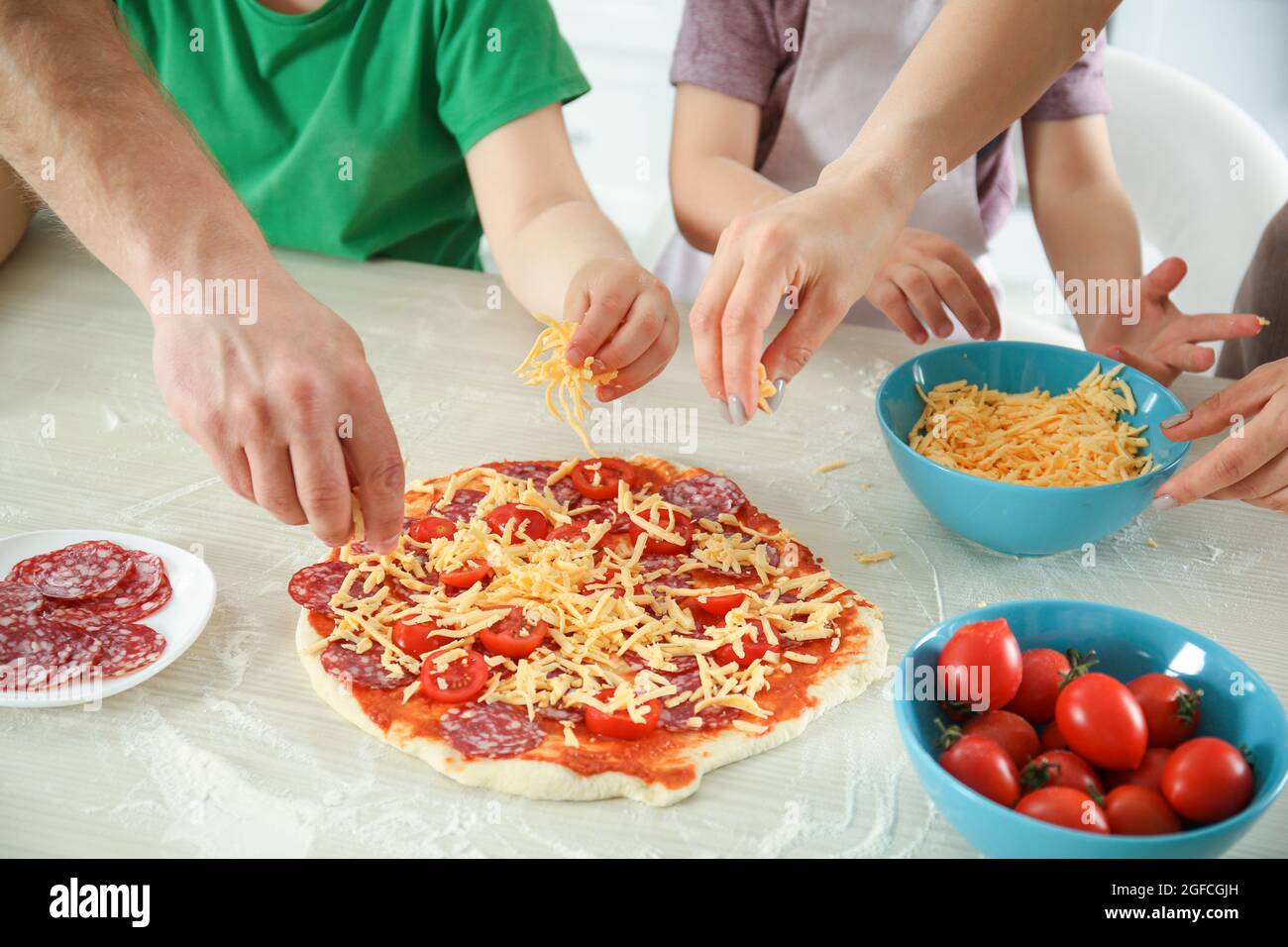 Kids with parents cooking dinner Stock Photo - Alamy