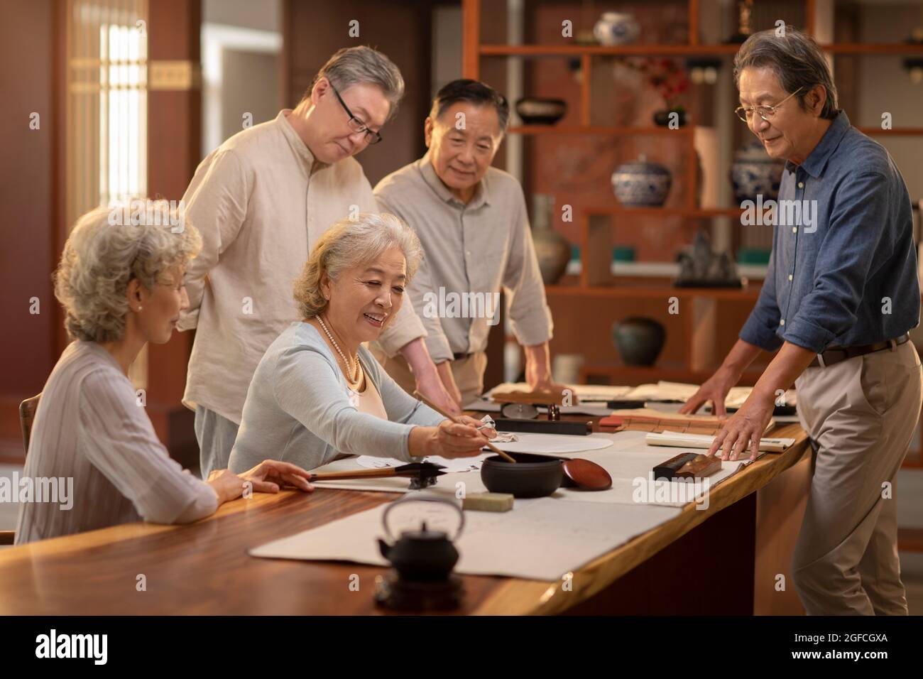 Happy friends practicing calligraphy together Stock Photo - Alamy