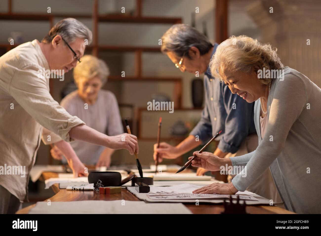 Happy friends practicing calligraphy together Stock Photo - Alamy