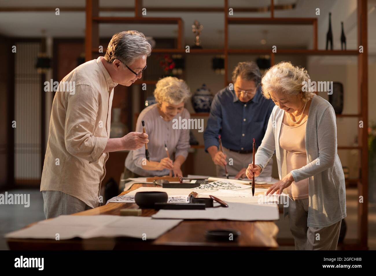 Happy friends practicing calligraphy together Stock Photo - Alamy