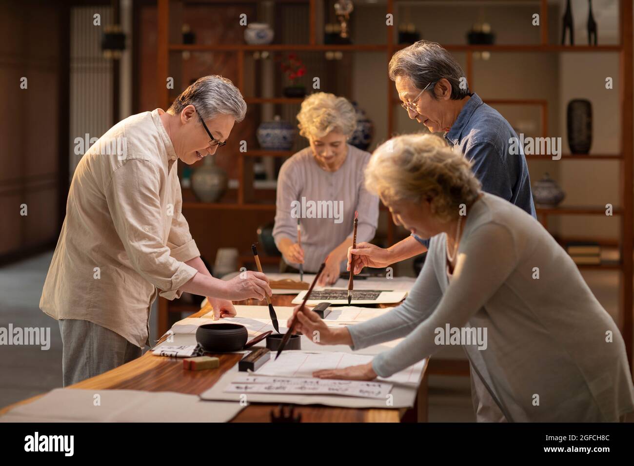Happy friends practicing calligraphy together Stock Photo - Alamy